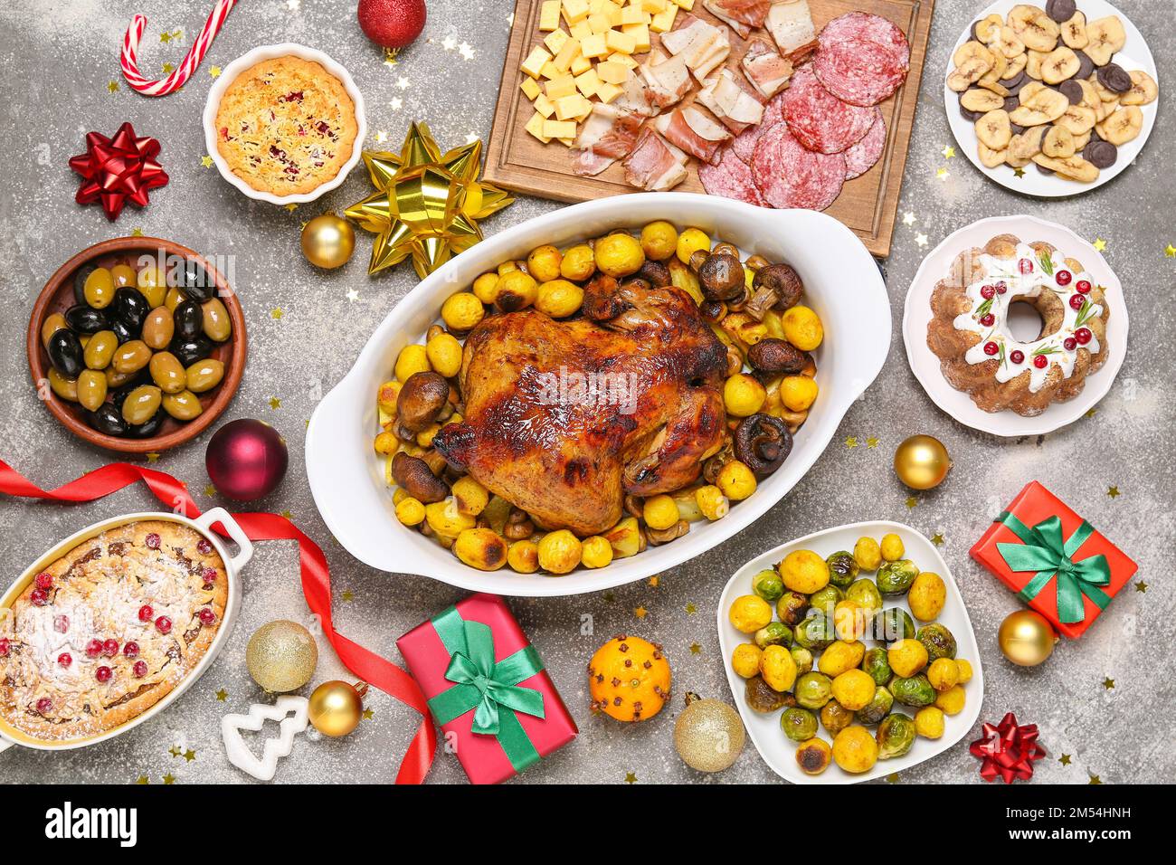 Christmas table setting with tasty chicken, pastries and gifts on dark ...