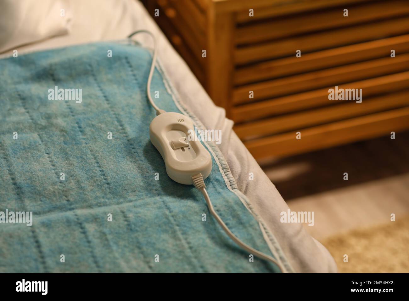 Electric heating pad with controller on bed at night, closeup Stock ...