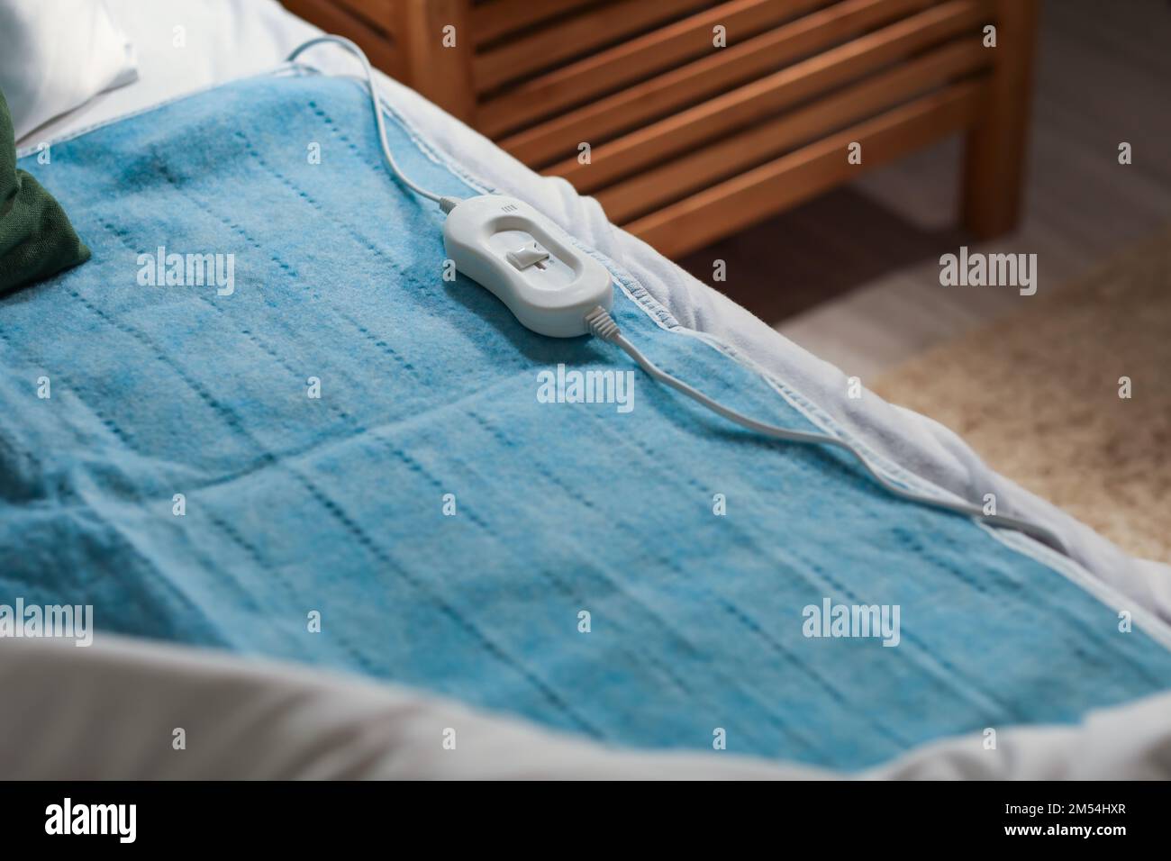 Electric heating pad with controller on bed at night, closeup Stock ...