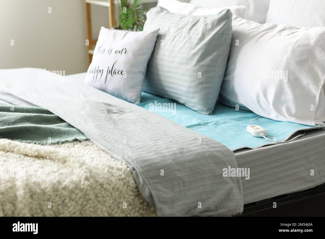 Bed with electric heating pad in bedroom Stock Photo - Alamy