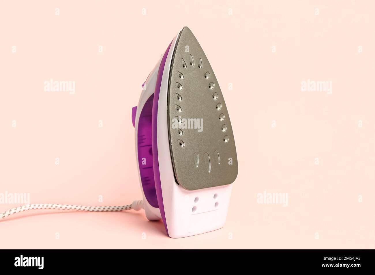 Electric iron on pink background Stock Photo - Alamy