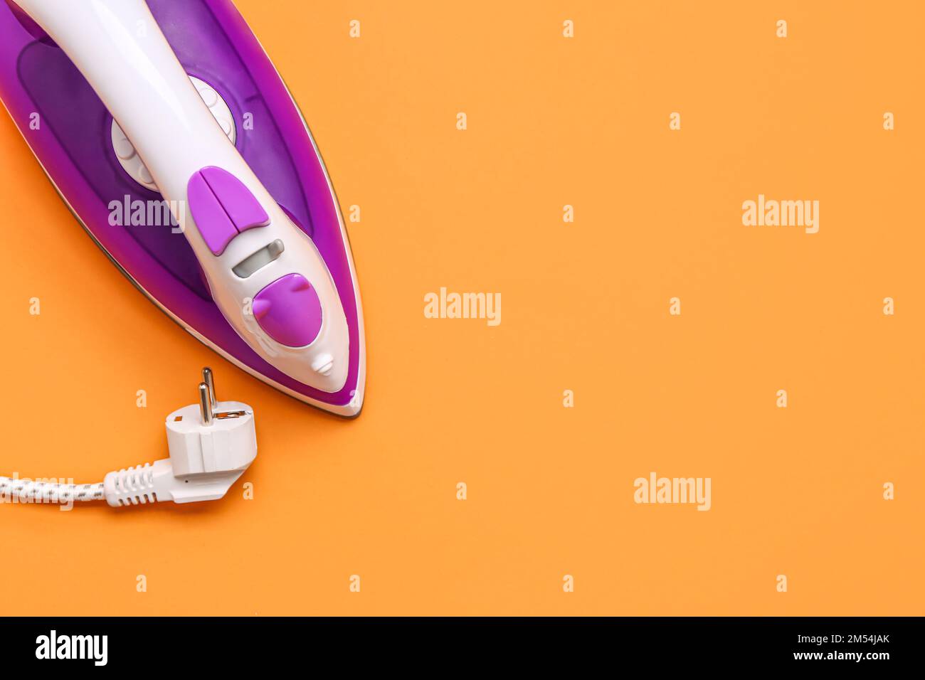 Electric iron on orange background Stock Photo - Alamy