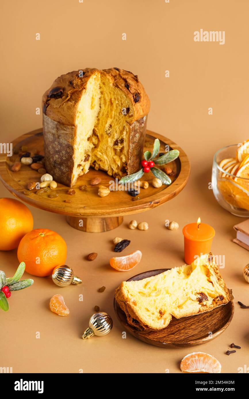 Stand with cut Panettone and Christmas decor on beige background Stock ...