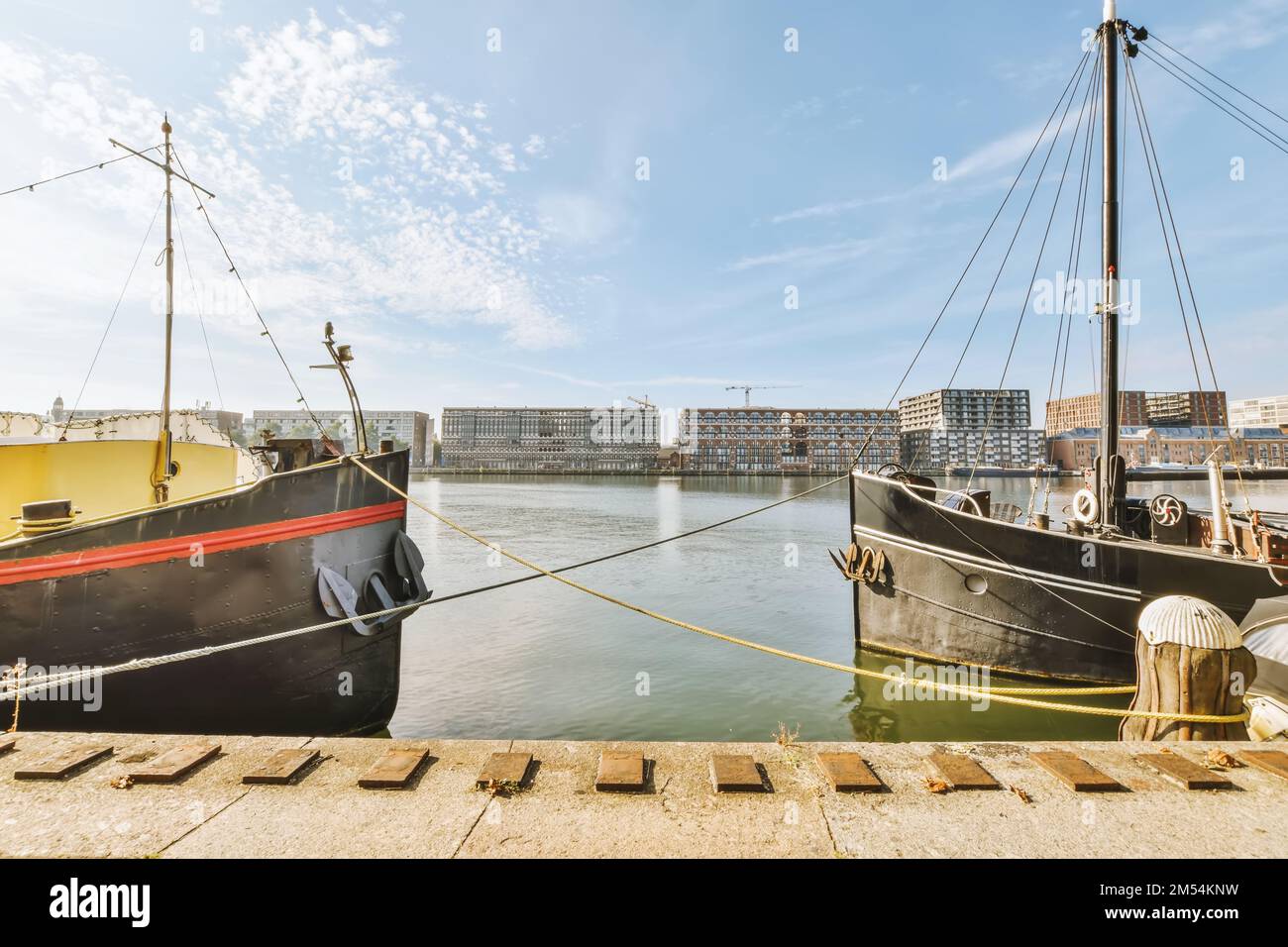 two boats docked at the dock in front of a large building and blue sky ...