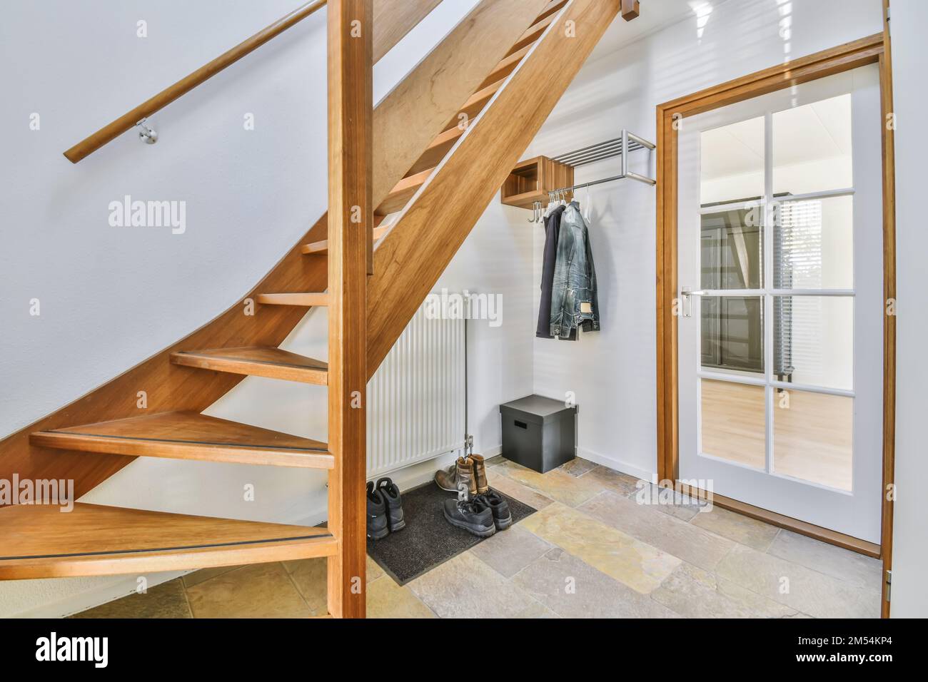 a wooden staircase in a room with white walls and wood steps leading up ...