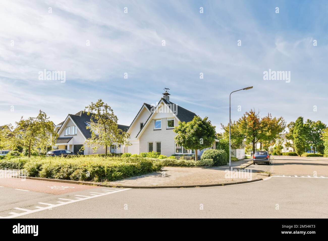 a street with houses and cars parked in the parking lot on either side ...