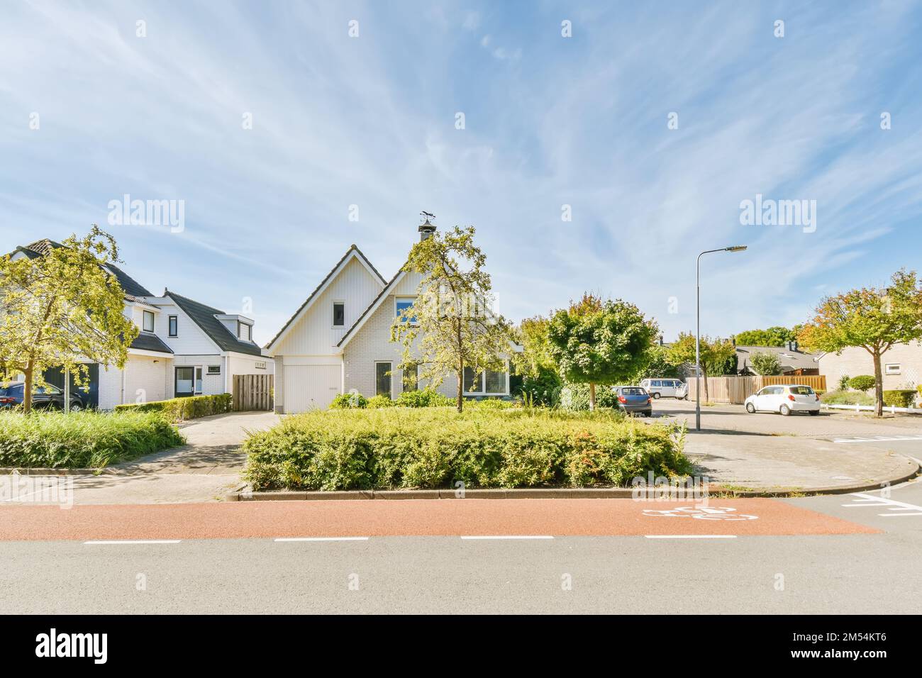 an empty street with houses in the background and blue skies overhead ...