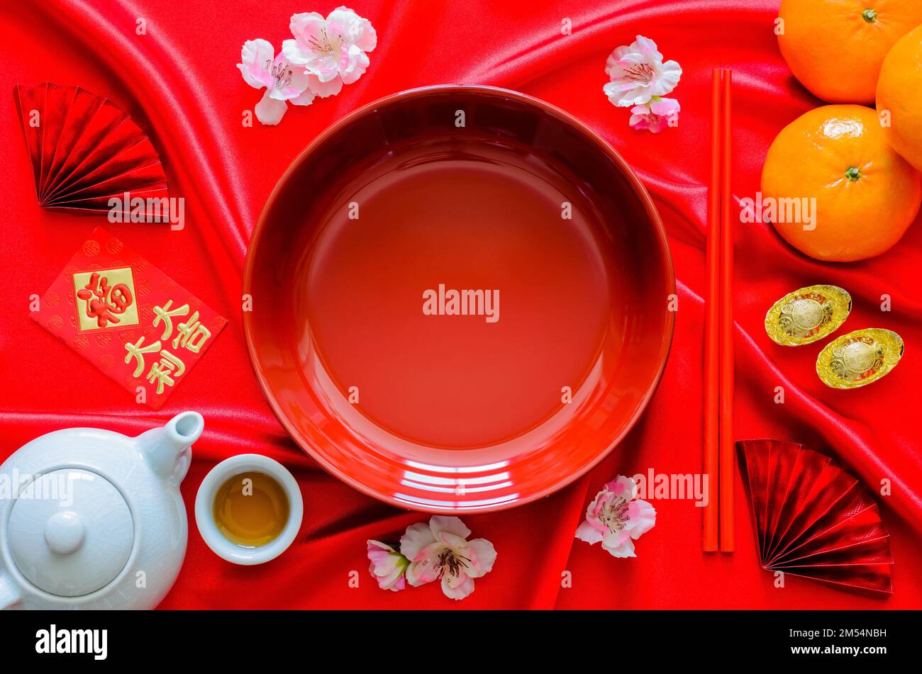 Red plate with chopstick on red satin cloth background with tea set ...