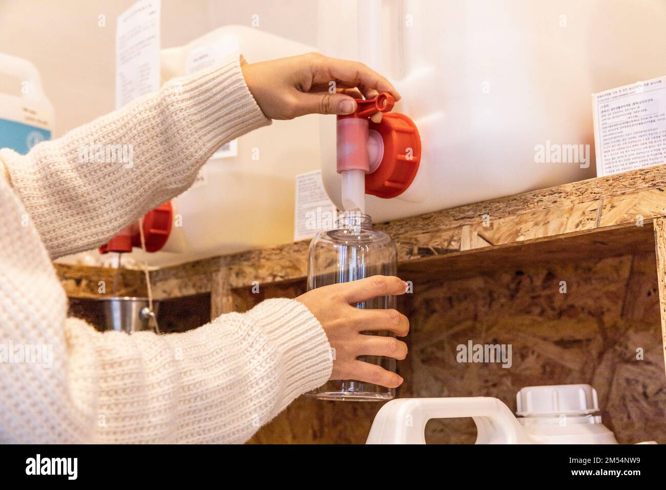 eco friendly habits hand gesture refilling detergent at zero waste shop ...