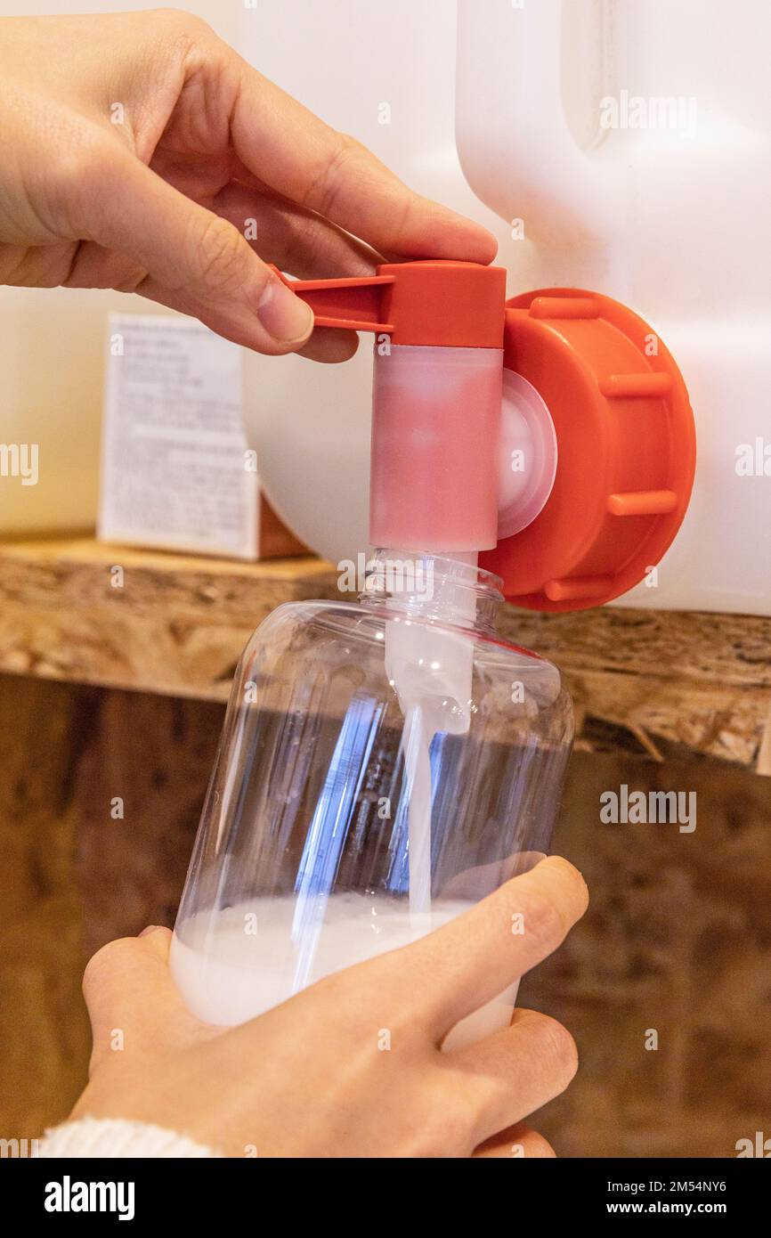 eco friendly habits hand gesture refilling detergent at zero waste shop ...