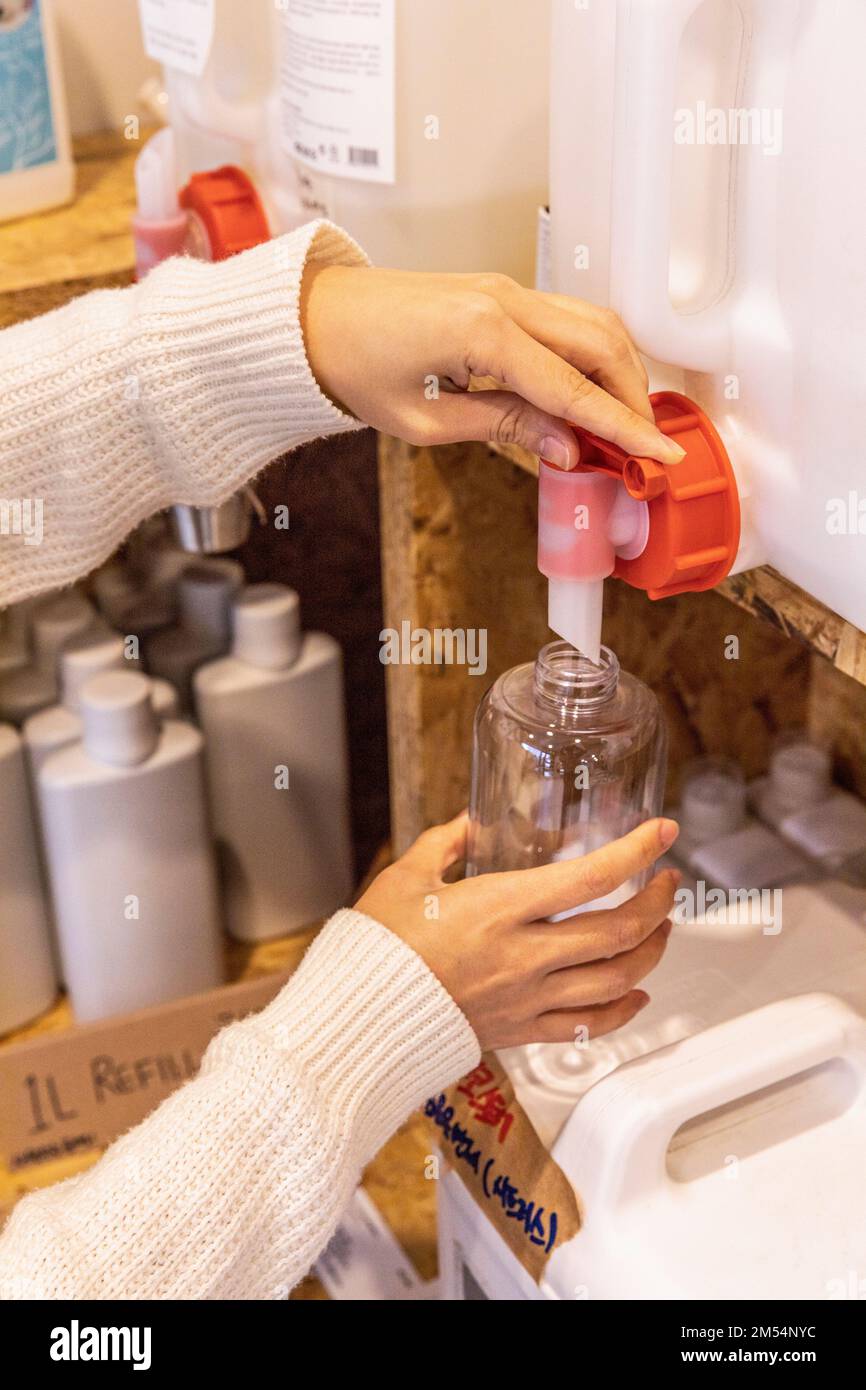 eco friendly habits hand gesture refilling detergent at zero waste shop ...