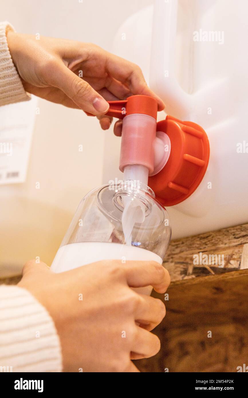 eco friendly habits hand gesture refilling detergent at zero waste shop ...