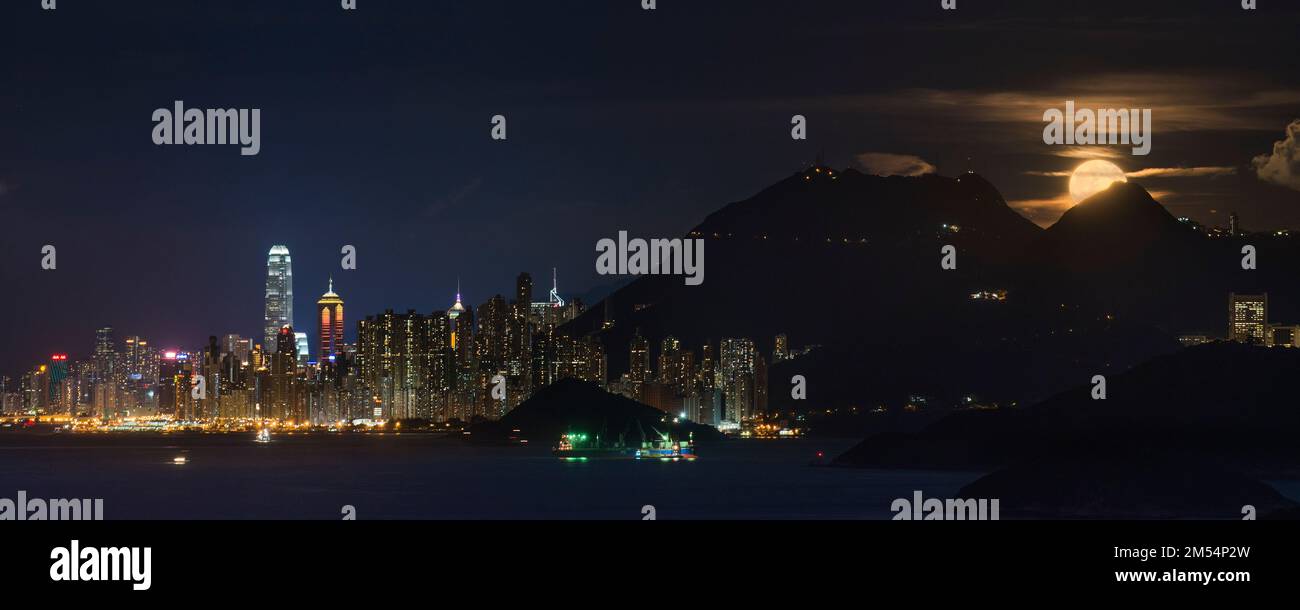 The full moon rises from behind High West, next to Victoria Peak, with ...