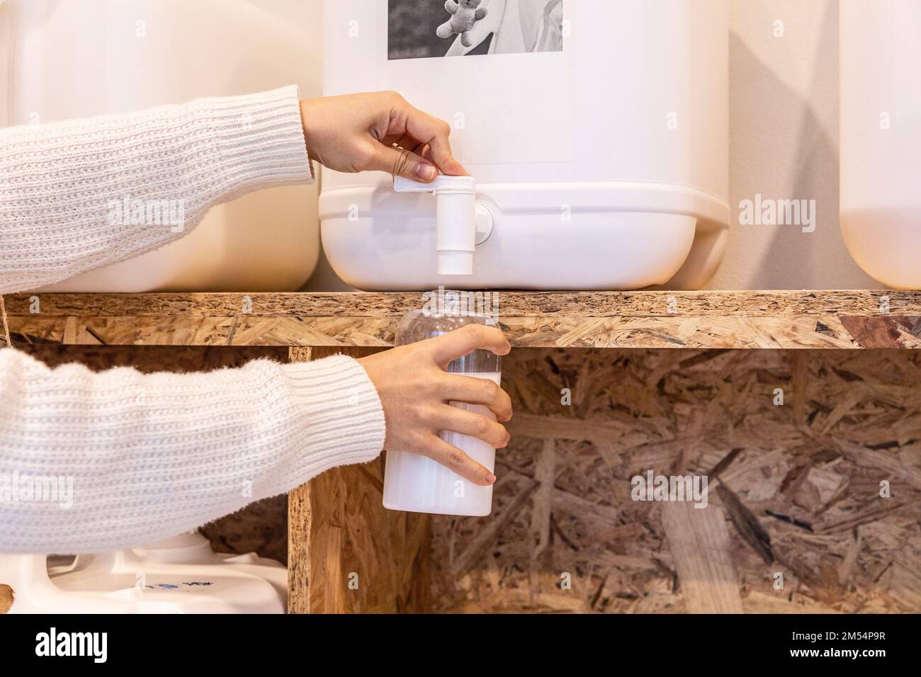 eco friendly habits hand gesture refilling detergent at zero waste shop ...