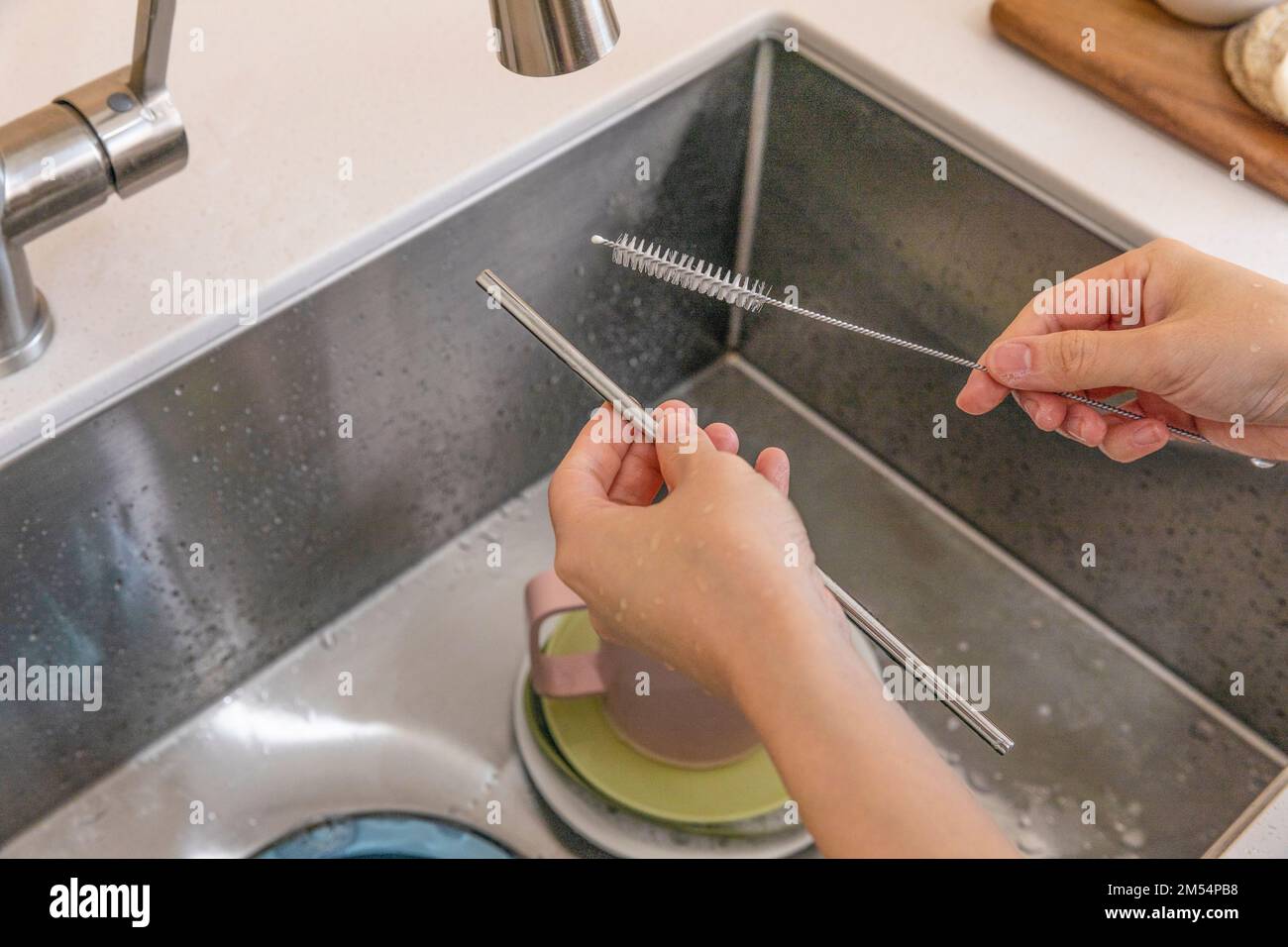 eco friendly habits hand gesture washing the stainless steel straw ...