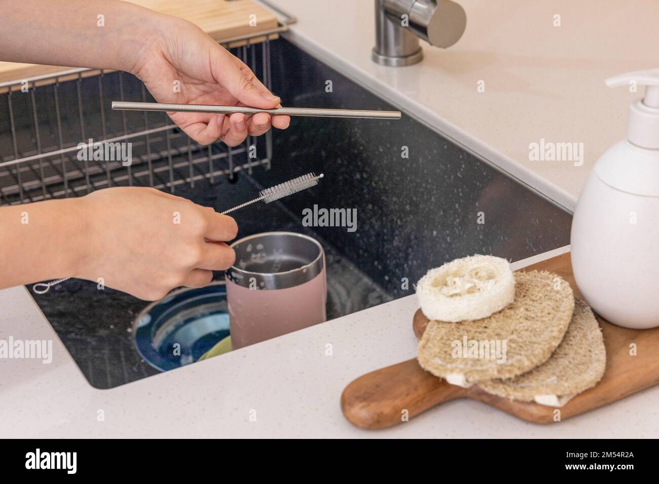 eco friendly habits hand gesture washing the stainless steel straw ...