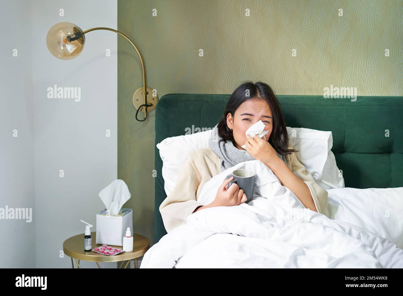 Covid-19, flu and vaccination concept. Korean girl lying in bed with ...