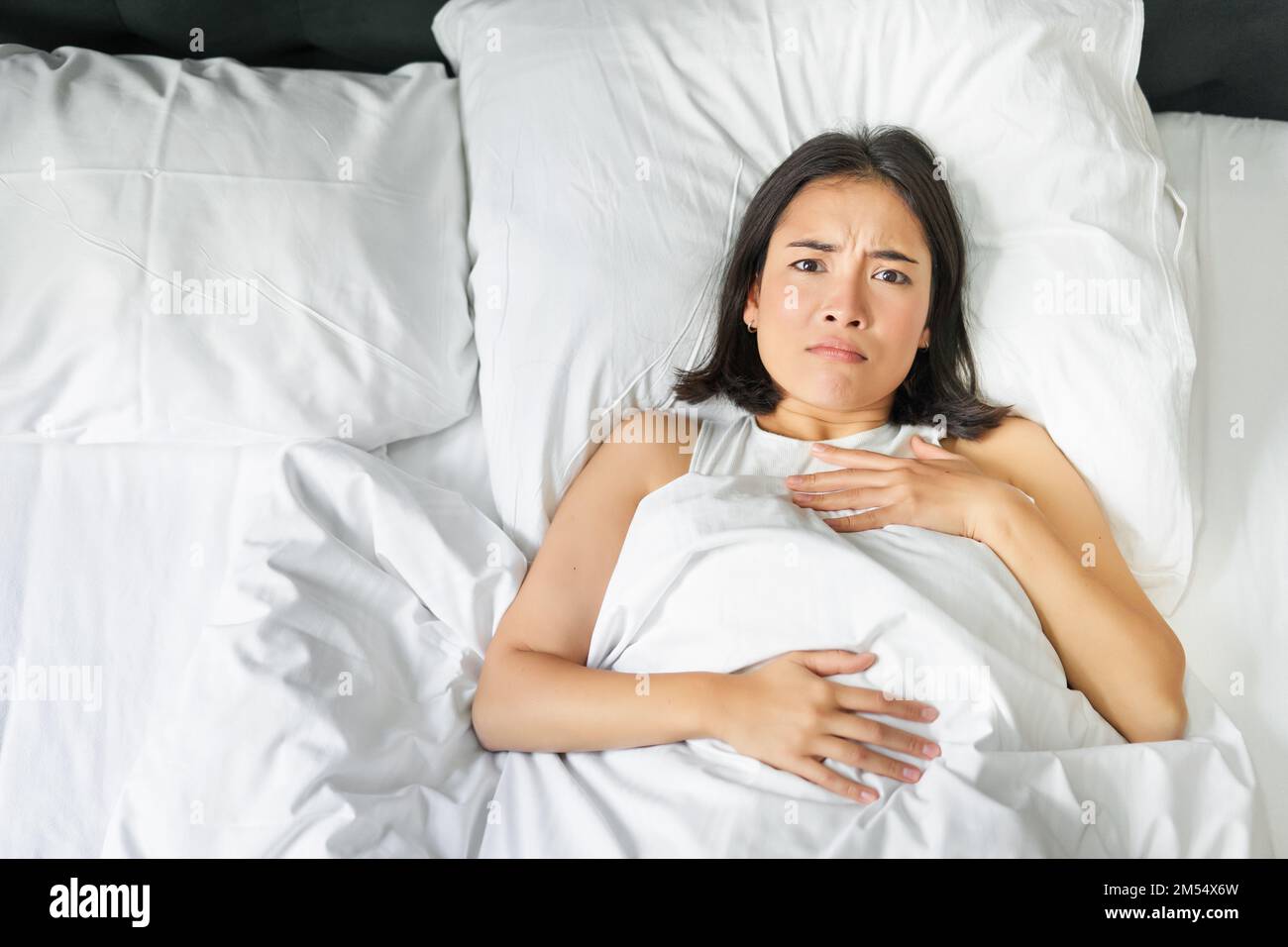 Portrait of sad young asian woman lying in bed, overthinking before ...