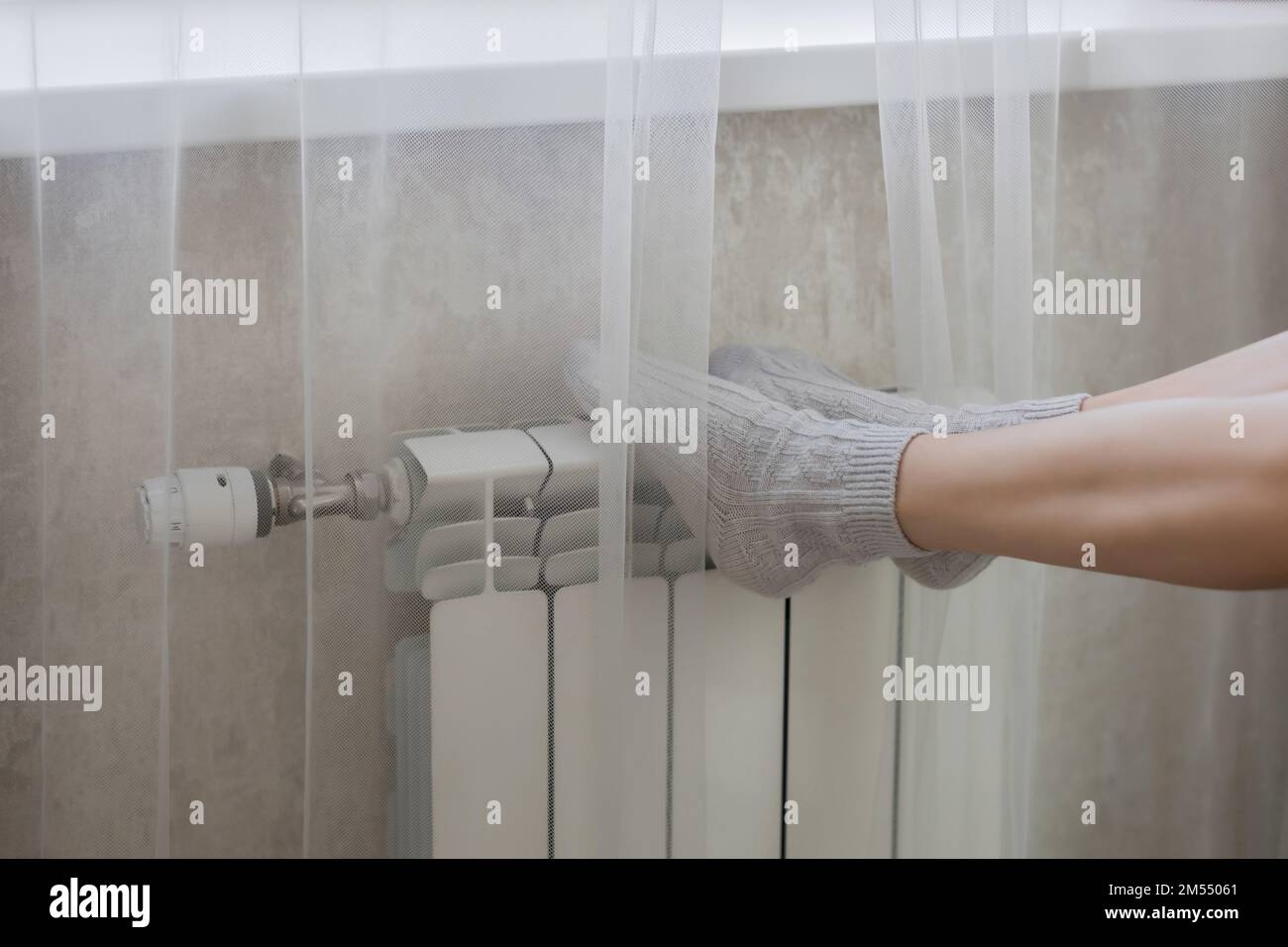female legs in socks on warm radiator. Woman warming up her feet Stock ...