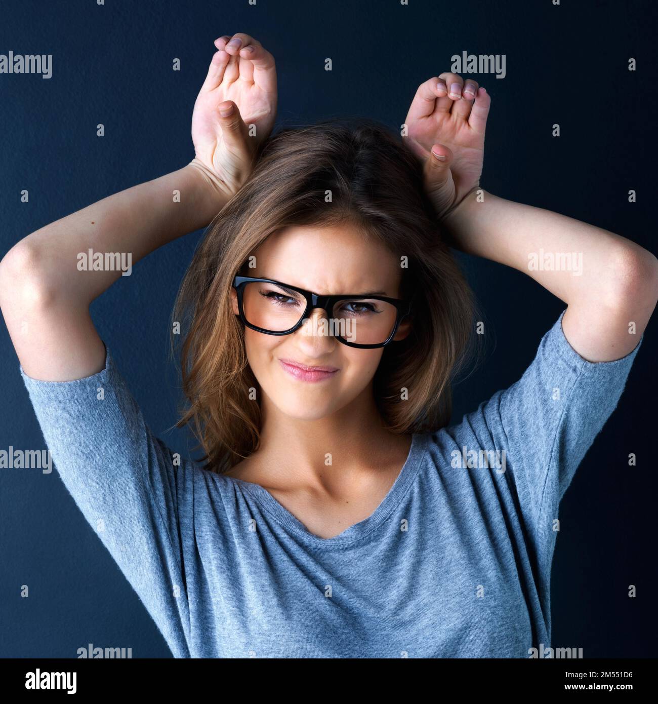 Foxy lady. Studio portrait of a teenage girl playfully making ears with ...
