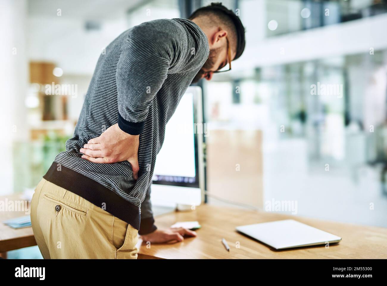 Poor posture is putting pressure on his back. a young designer ...