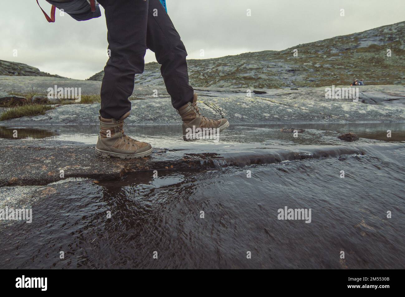 Hiker walking across shallow mountain river scenic photography Stock ...