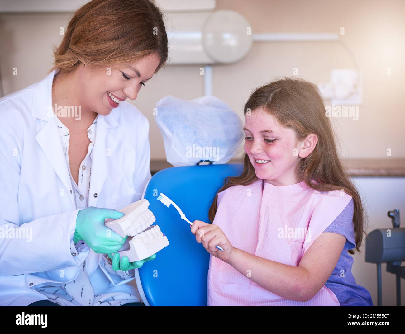 Lets chat about good oral-hygiene habits. a female dentist teaching her ...