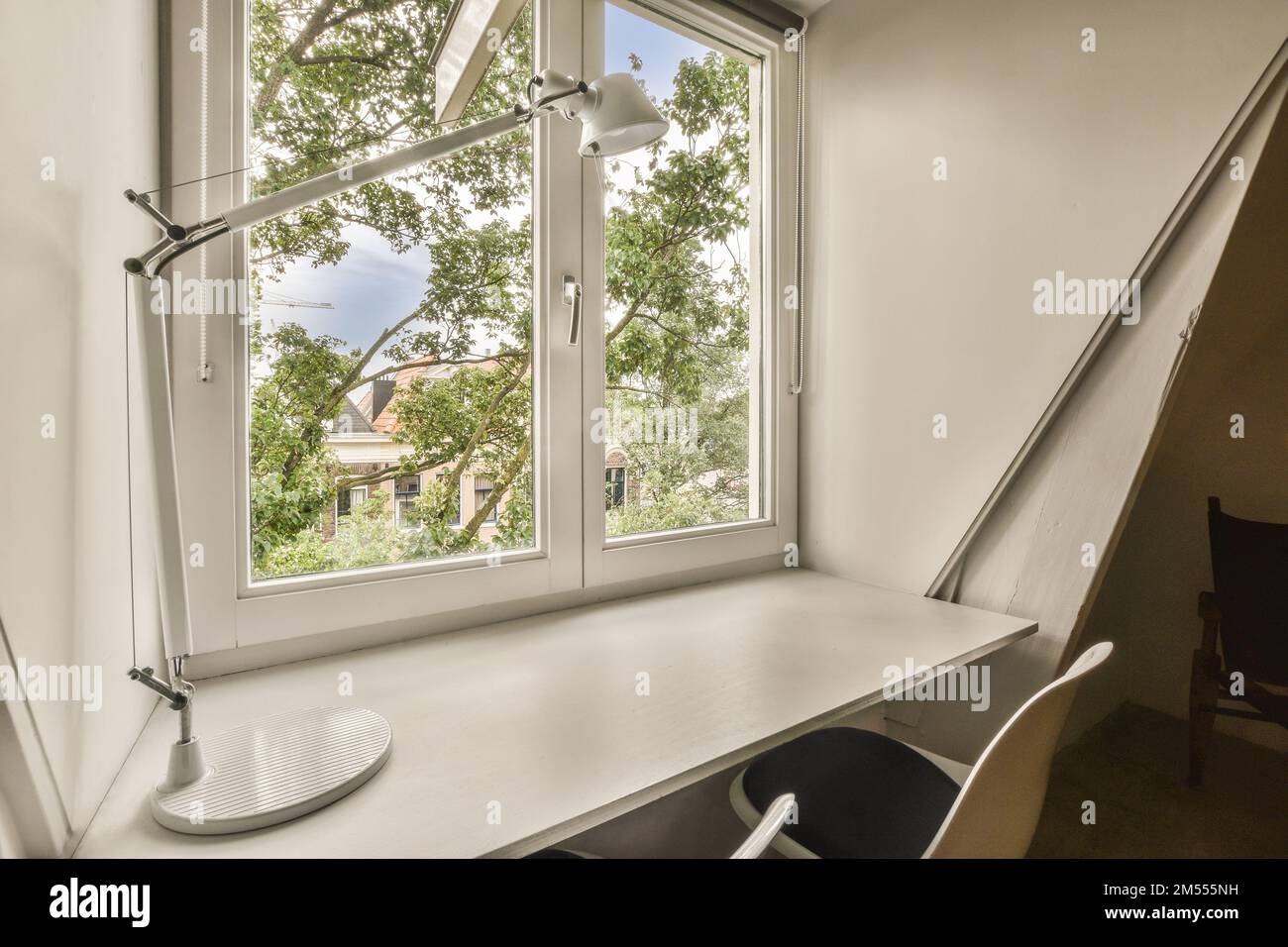 a desk and chair in front of a window looking out onto the street with ...