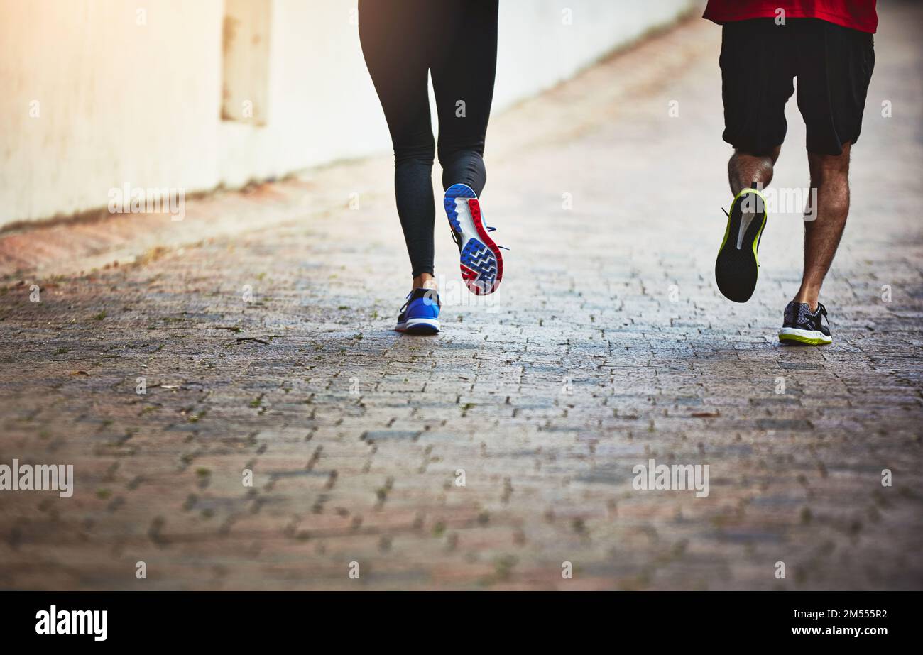 Running towards a healthier future. a couple out running together Stock ...