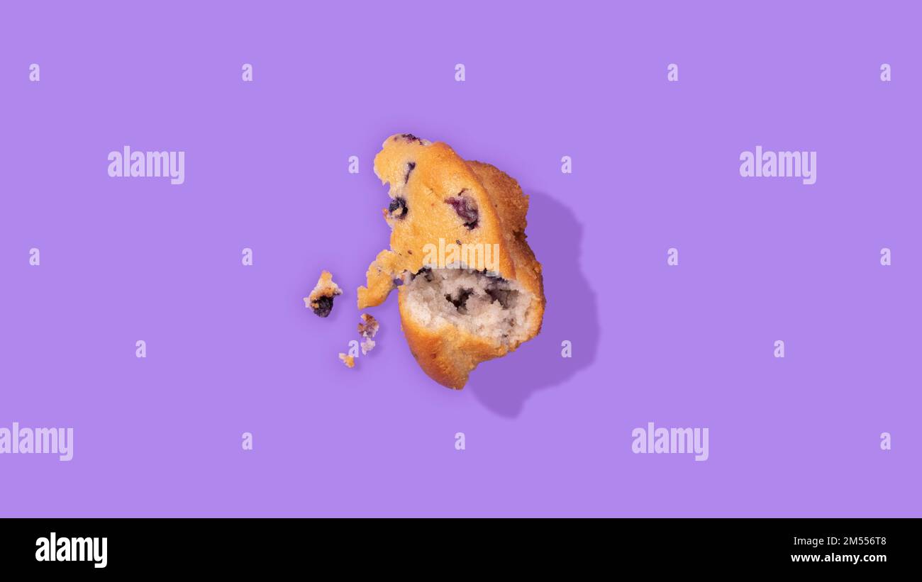 A bitten blueberry muffin isolated on a purple background Stock Photo ...