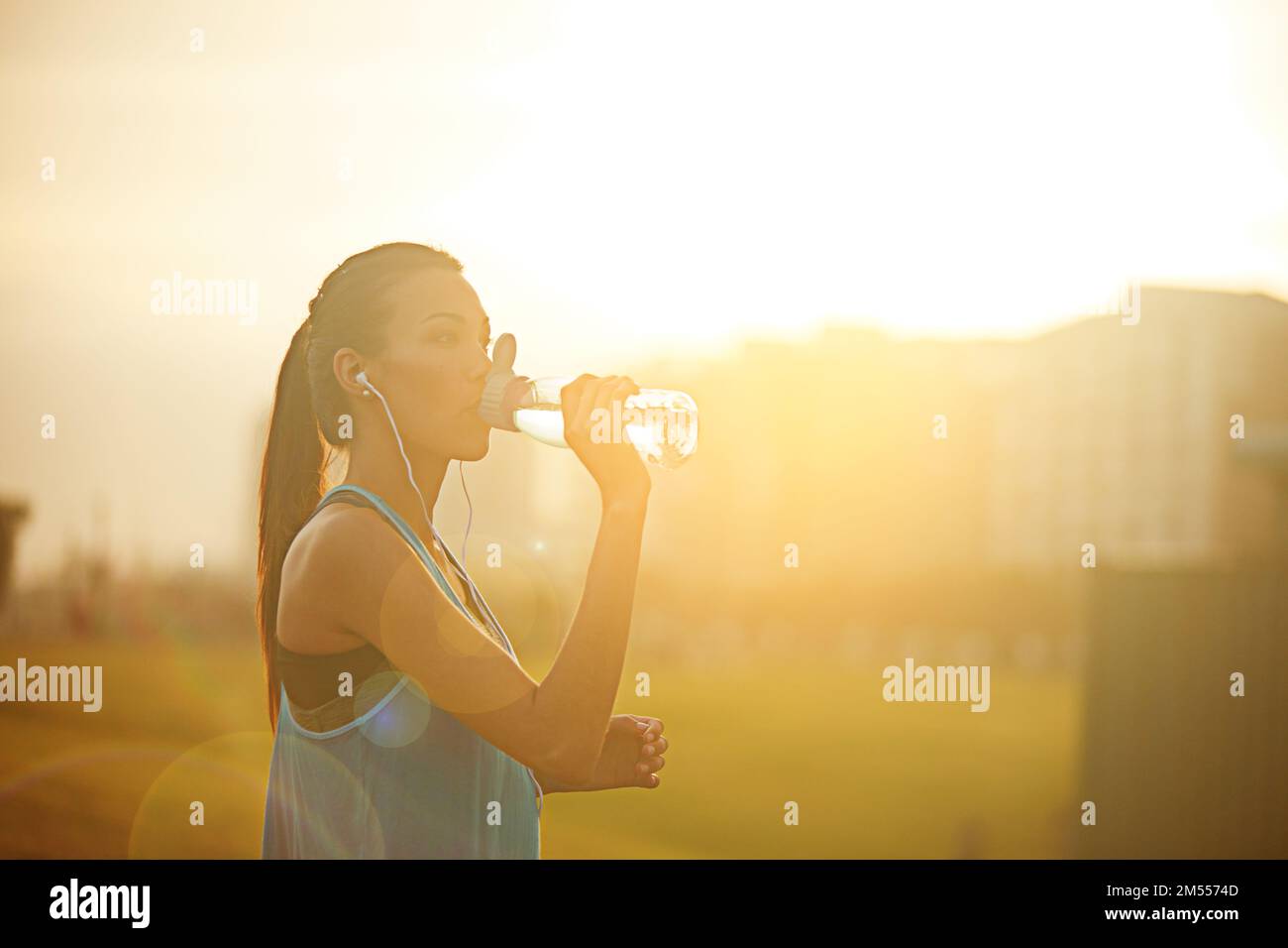Drink up before you run yourself down. a young woman drinking water ...