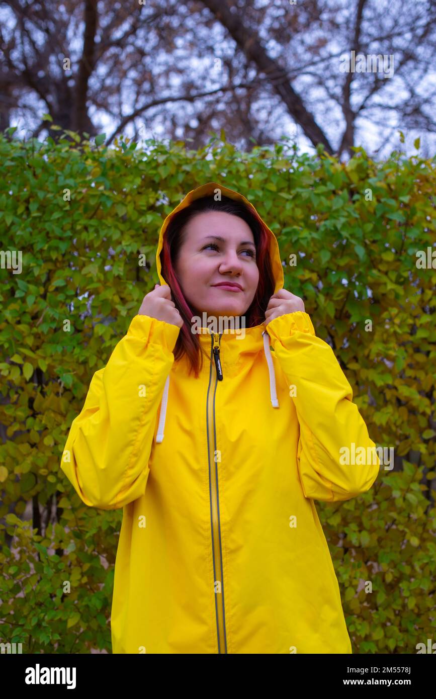 the portrait of a girl in a yellow jacket against a background of trees ...