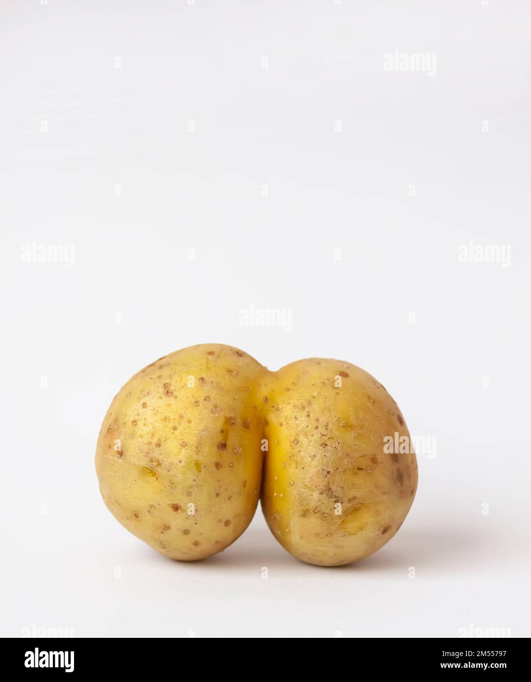 Raw funny potato in a shape of ass on white background Stock Photo - Alamy