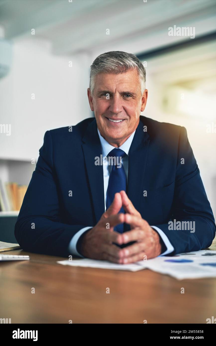 Like a boss. Portrait of a confident businessman posing behind his desk ...