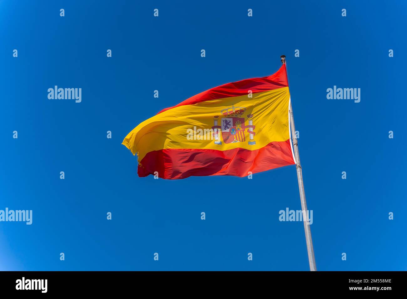 A low angle shot of a Spanish flag waving in a bright blue sky Stock ...