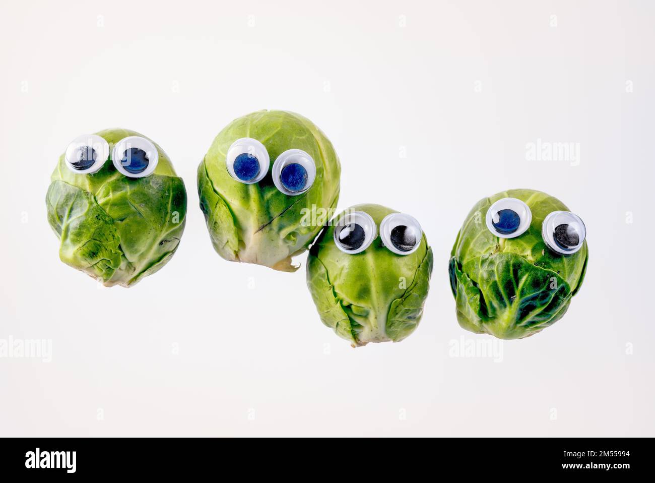 group of brussel sprouts with funny googly eyes isolated on a white ...