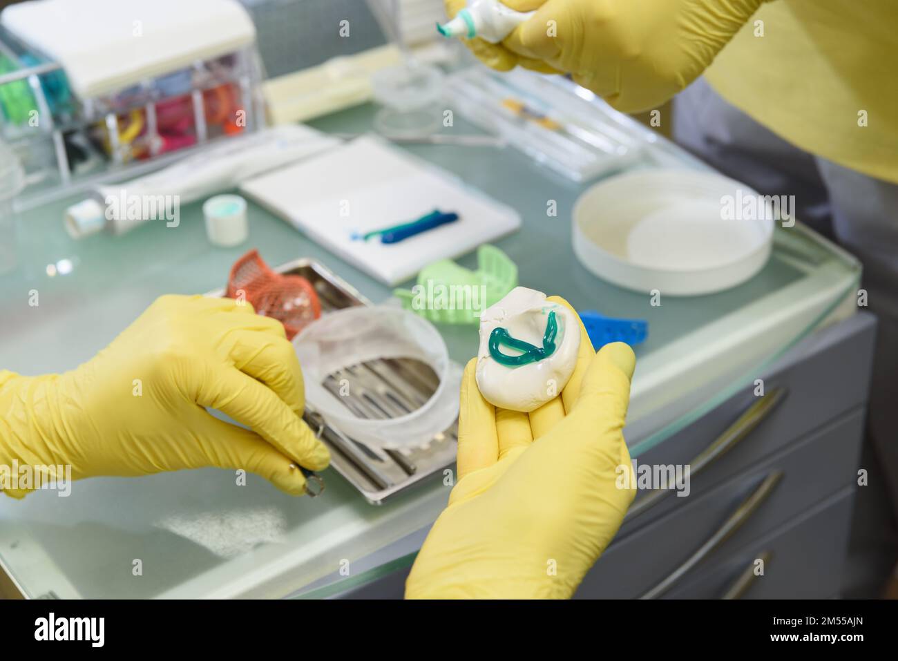 The orthodontist prepares a special paste for making an impression of ...