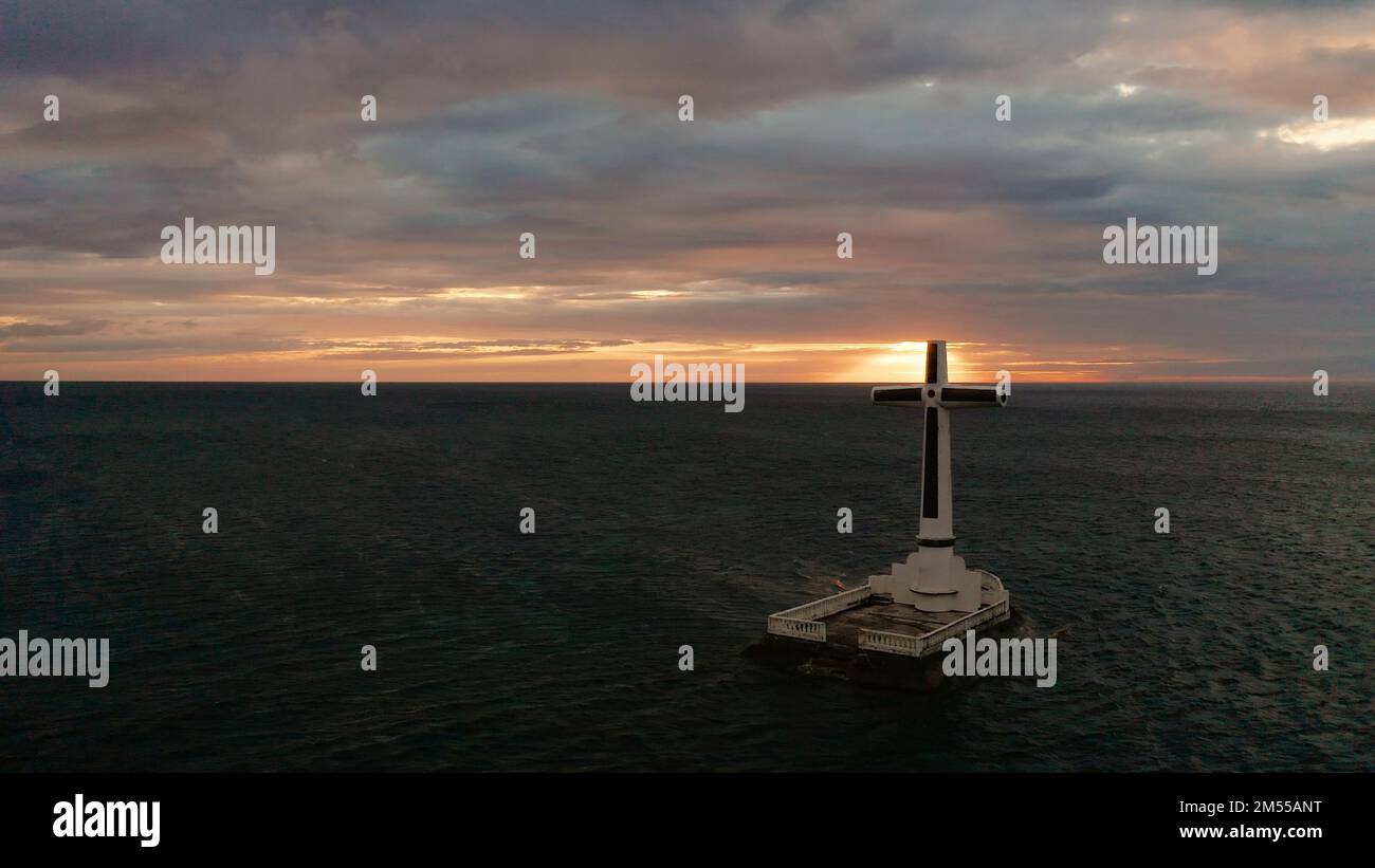 Catholic cross in sunken cemetery in the sea at sunset, aerial drone ...
