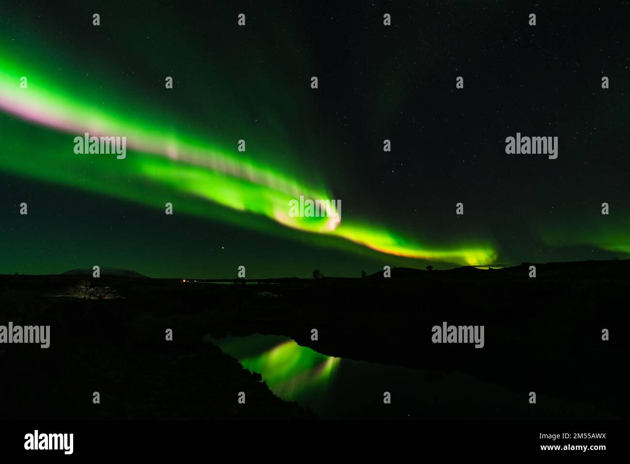 Northern lights pink and green light beams over the lake Stock Photo ...