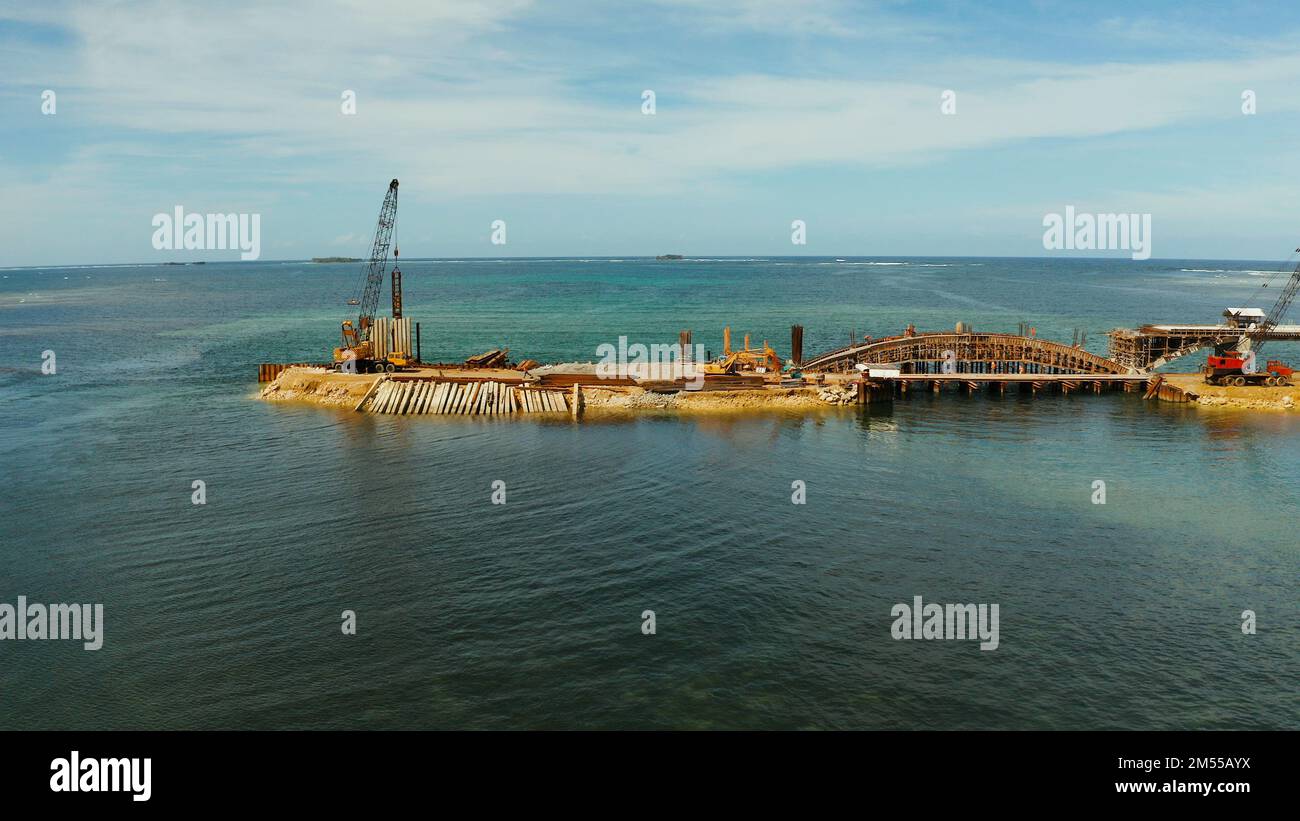 Bridge under construction over the sea bay connecting the two parts of ...