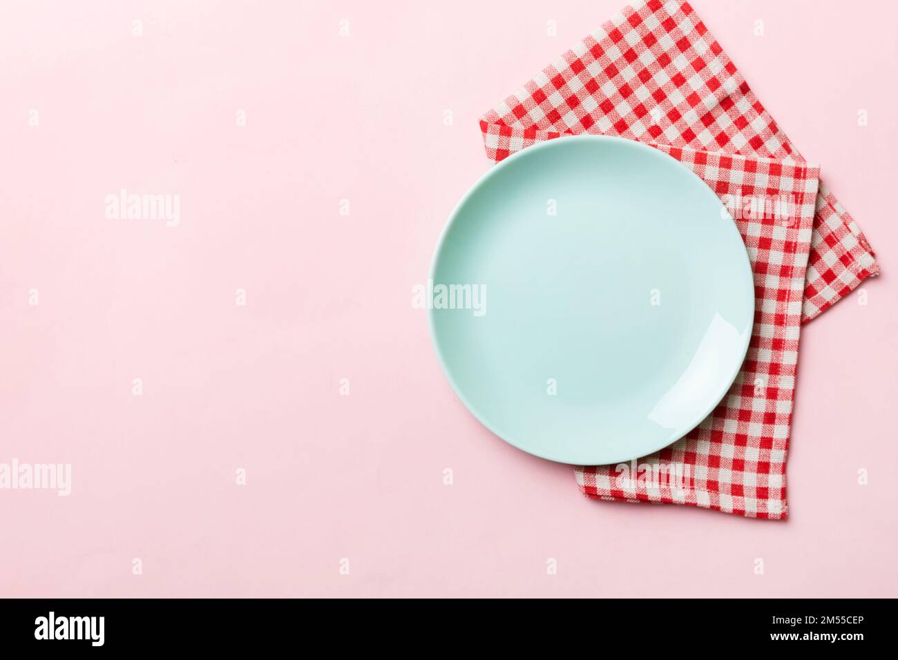 Top view on colored background empty round Blue plate on tablecloth for ...