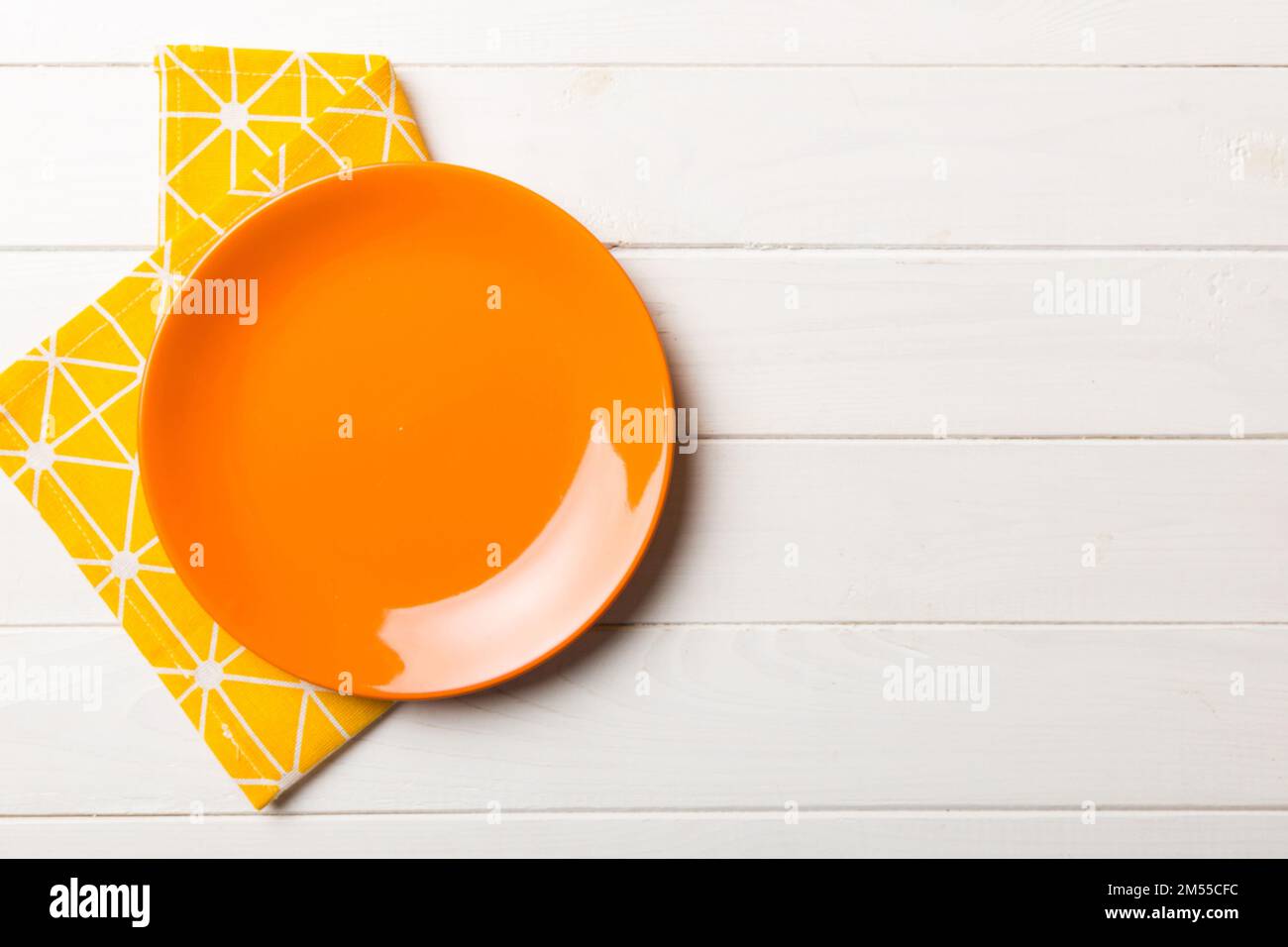 Top view on colored background empty round red plate on tablecloth for ...
