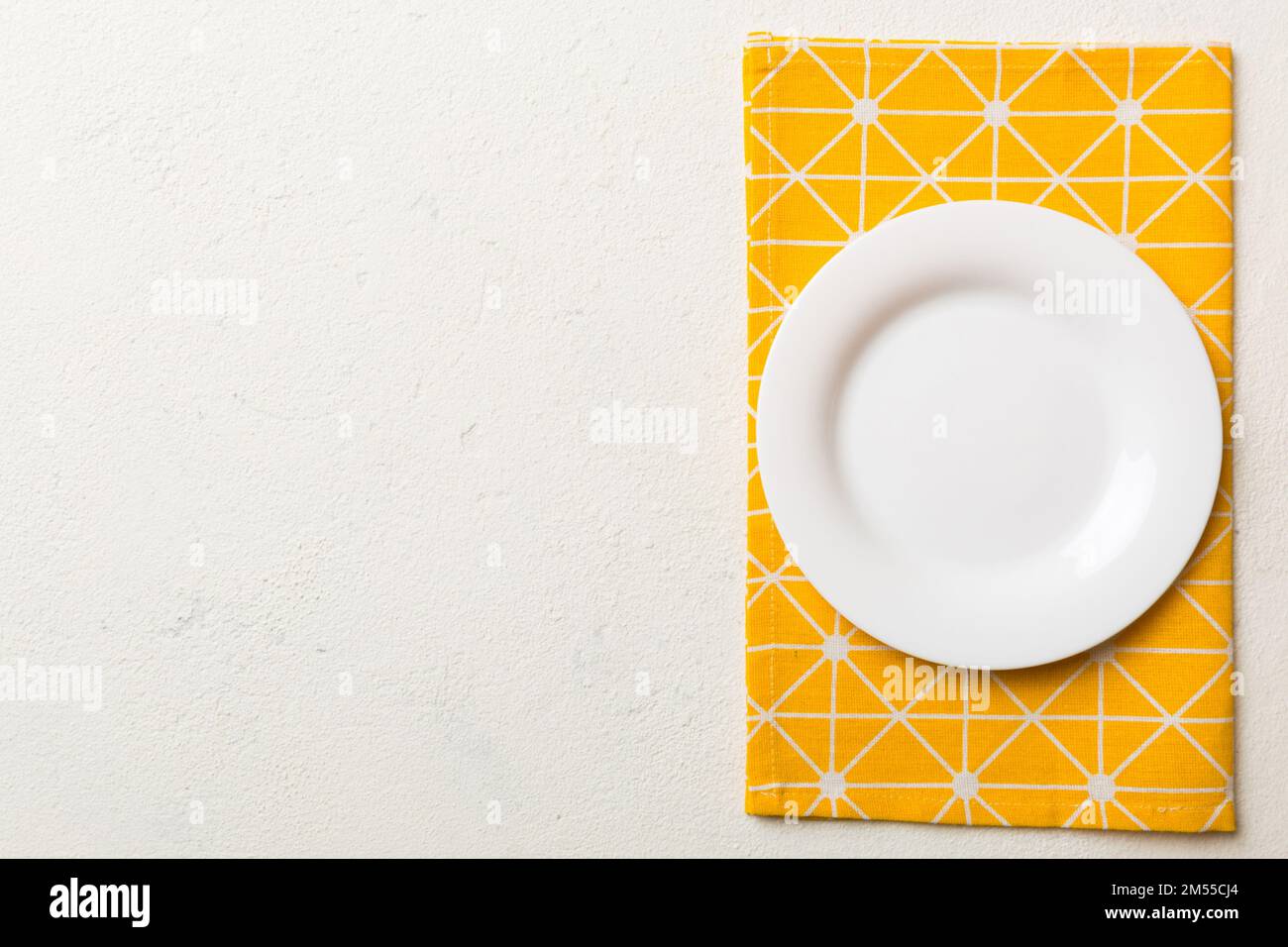 Top view on colored background empty round white plate on tablecloth ...