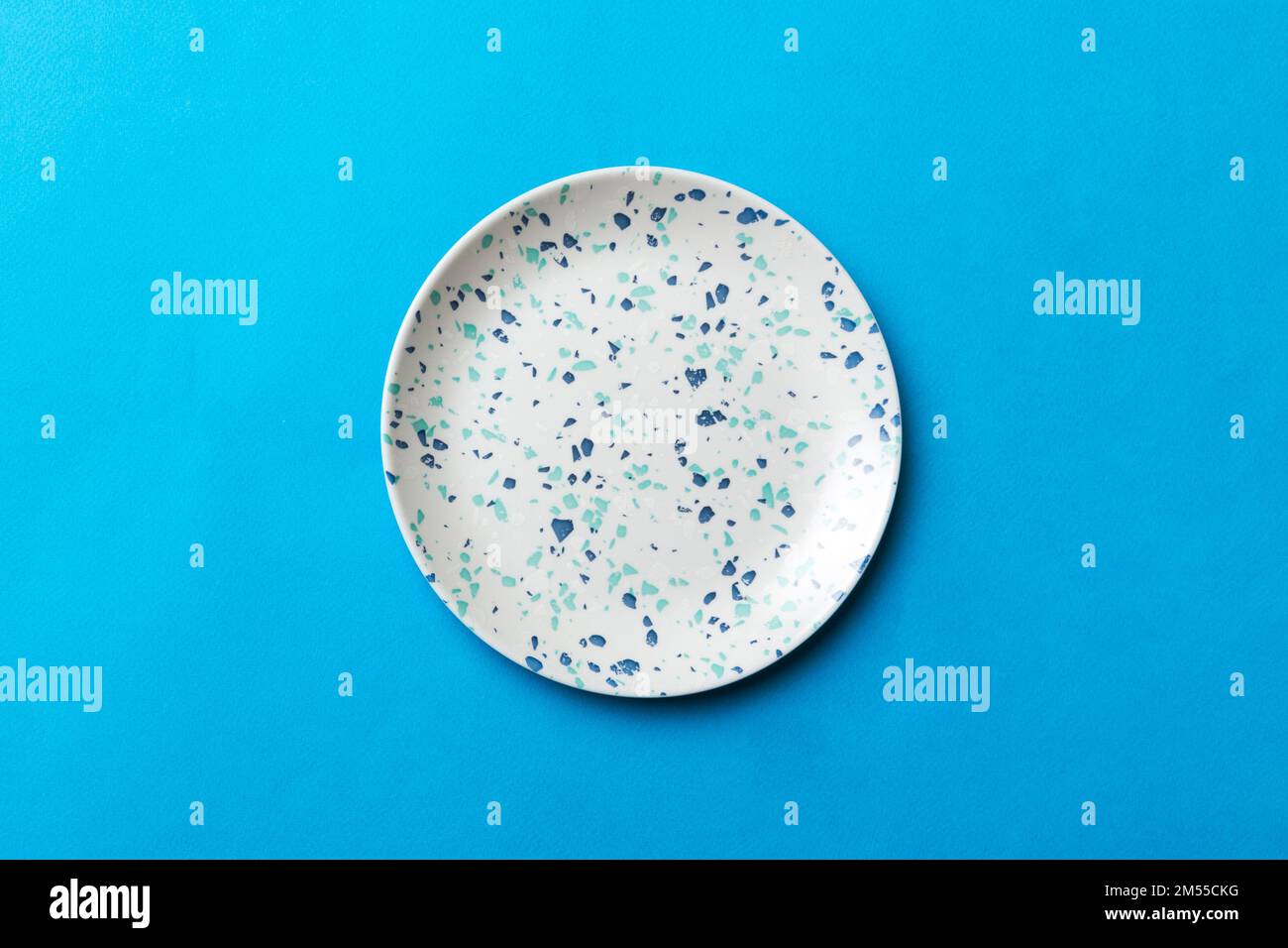 Top view of isolated of colored background empty round blue plate for ...
