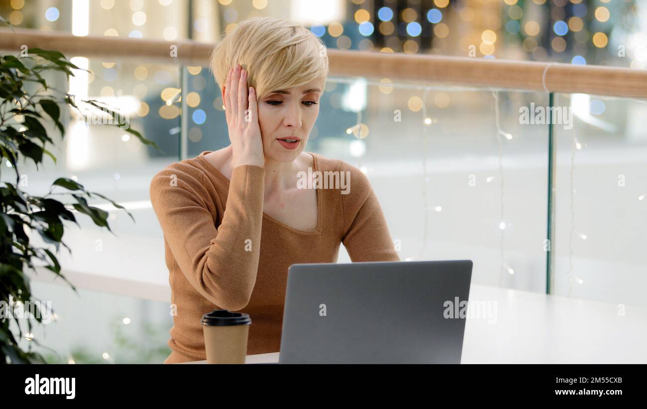 Caucasian middle aged mature 40s business woman with laptop working ...
