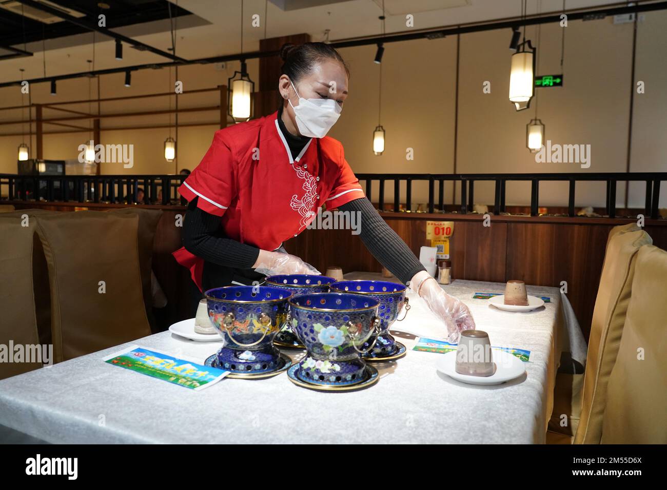 Beijing, China. 25th Dec, 2022. A waitress sets the table at a ...