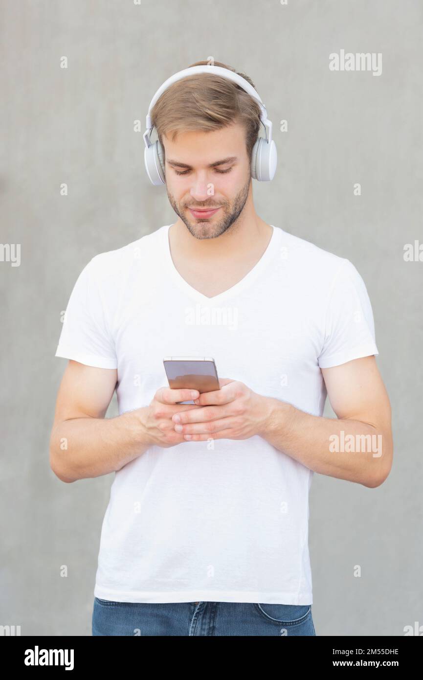 young man choose mp3 music playlist wearing white shirt. photo of man ...