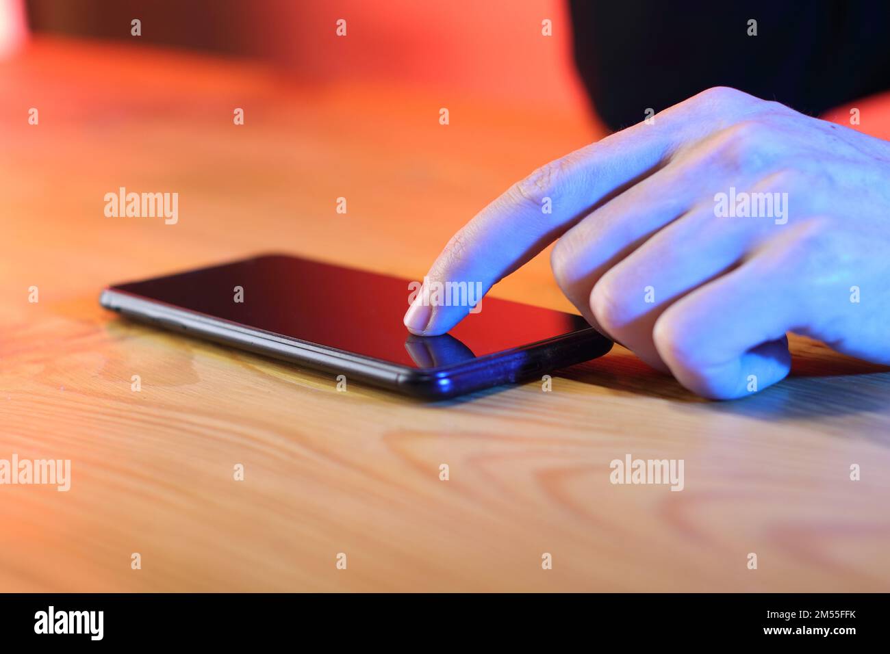 finger touching smartphone on table and colored background Stock Photo ...