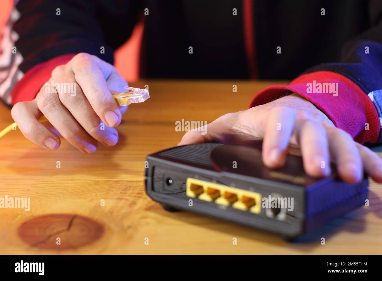 connecting internet cable to old adsl modem on table by background ...