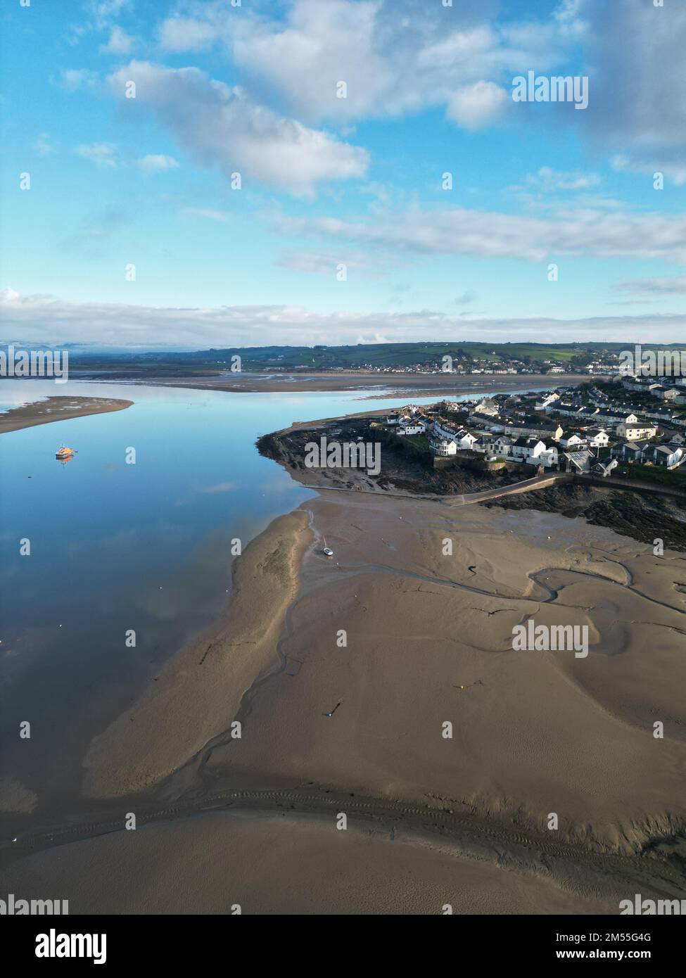 A vertical drone shot of a shallow river with reflections in Appledore ...